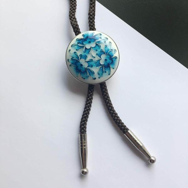 唐草模様を現代風にアレンジし、透き通るような美しい作品に仕上げました。シルクの紐を使用し、長く使っていただける品です。職人がひとつひとつ手作業で銀線を立てておりますので、同じデザインでも表情が異なります。胸元を華やかに彩り、目を引くアクセサ...