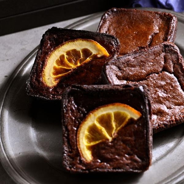 最高級クリームチーズを使ったバスクチーズケーキの生地に、ショコラを練り込んでしっとり濃厚な口当たりに焼きあげた逸品。チーズの風味やカラメルの苦みが程よく調和した「ショコラ」と、そこに柑橘の爽やかさを重ねた「ショコラオレンジ」の2種4個入り。
