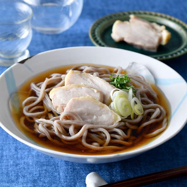 山形県河北町の名物「冷たい肉そば」は初夏にぴったり。月山の湧き水で打った蕎麦は挽きぐるみの田舎風で、豊かな風味と弾力のある歯応えがたまらない。親鶏のダシを利かせたツユのコク、しっとり柔らかな鶏の一夜干しとの相性も圧巻。力強くも滋味深い一杯に唸る!