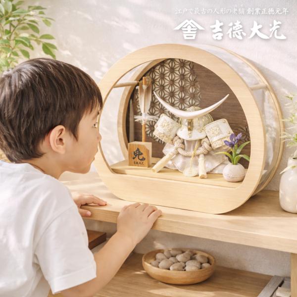 【江戸時代で最古の人形の老舗：創業正徳元年 吉徳大光】五月人形 アクリルケース伊達政宗の兜。円形でおしゃれな木目調のケース枠は人気があります。ケースの背面の幾何学模様が高級感があり、正絹縅を使用した兜も吉徳ならではの豪華さです。軽くて割れに...