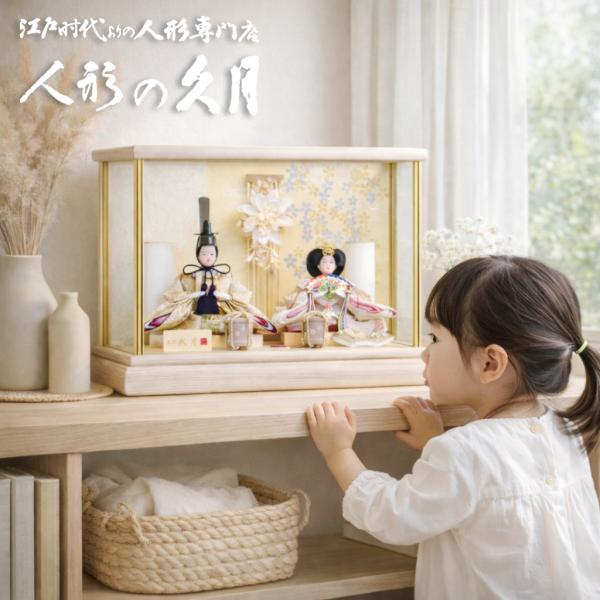 久月の雛人形が、ネット限定　ご奉仕価格「東京浅草橋 人形の久月」 ひな人形 親王ケース飾りです。人気の木目枠のケース飾りで、センターにはフラワーアレンジメントが目を惹きます。前飾りにもトーンを抑えたお洒落な造りのジュエリーを配置。お着物もト...