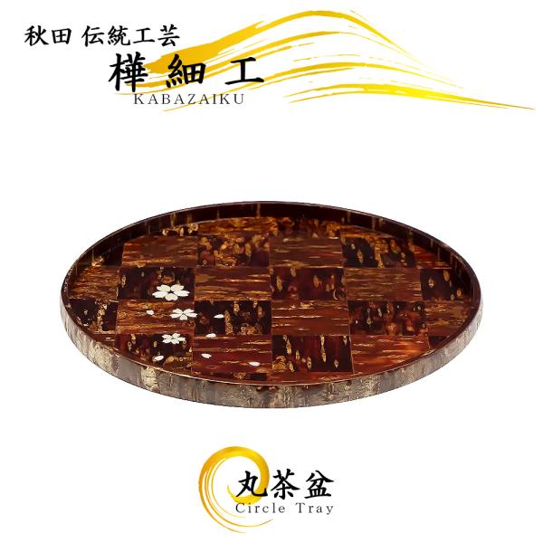 樺細工の「丸茶盆 市松桜 トレイ（中）」は、秋田の伝統工芸である桜皮細工を用いた逸品です。和モダンなデザインが特徴で、伝統と現代の美を見事に融合させています。市松模様に桜のモチーフが施され、上品で落ち着いた雰囲気を演出します。小ぶりなサイズ...