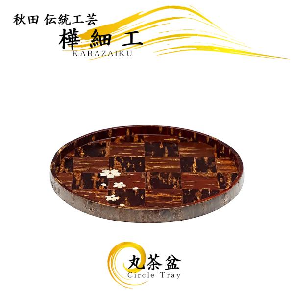 樺細工の「丸茶盆 市松桜 トレイ（小）」は、秋田の伝統工芸である桜皮細工を用いた逸品です。和モダンなデザインが特徴で、伝統と現代の美を見事に融合させています。市松模様に桜のモチーフが施され、上品で落ち着いた雰囲気を演出します。小ぶりなサイズ...