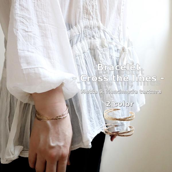 数量限定です。可憐な線の細さ ハンドメイドだから伝わる繊細な表情。1本1本表情の違う繊細な細い線を集めてクロスさせたデザインのブレスレット。少し間を広げて違う雰囲気にしたりアレンジが可能です。金属を叩いて入れる模様、ハンマーテクスチャーが作...