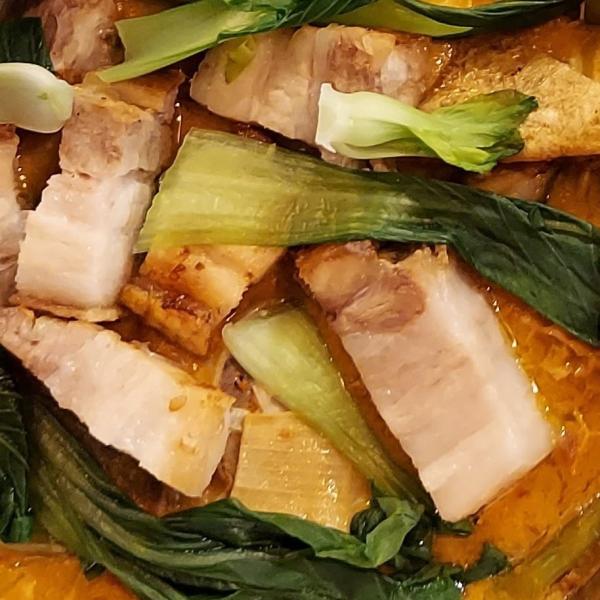 豚肉をインゲン豆、ナス、チンゲン菜等の野菜をピーナッツソース、アツエテフルーツ（紅の木）で煮込み、片栗粉でとろみをつけたシチューに似たフィリピンの祭事の伝統料理。エビの塩辛（バゴオン）をトッピングして食べるといいアクセントに！アレルゲン表示...