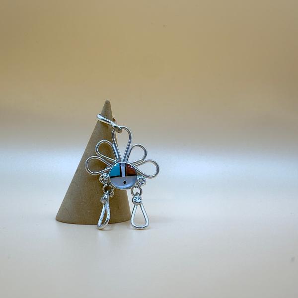 ズニ族の「Tohya OLA Eriacho」氏作ターコイズやコーラルの様々なストーンとシェルをカットしてはめ込んだインレイワークの技法が魅力的です。デザインはサンフェイスにヘッドドレスとセットしておりネイティブアメリカンらしい仕上がりです...