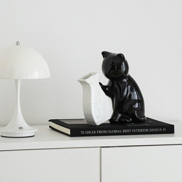 猫が花瓶をちょんと押して、今にも倒してしまいそうな瞬間を切り取った、遊び心のあるフラワーベースです。いたずら好きの猫らしい仕草をそのままデザインにしており、どこかクスッと笑えるような愛らしさがあります。陶器ならではのつややかな質感が美しく、...