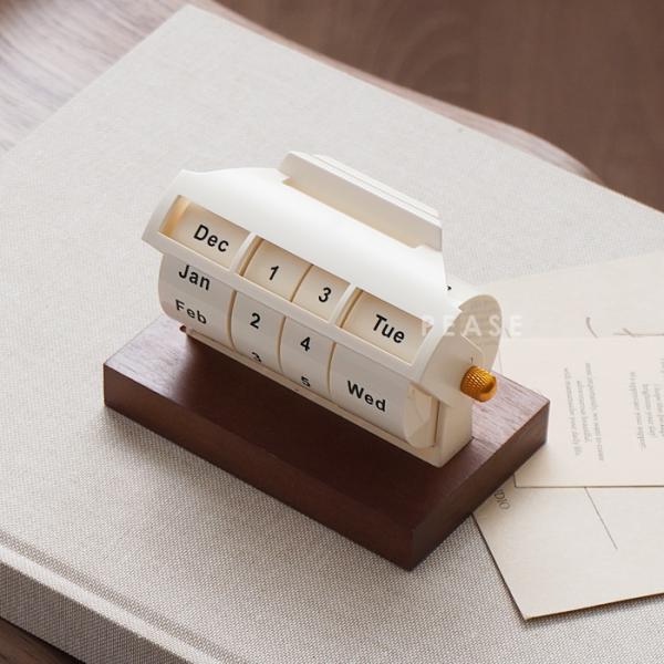 シンプルかつおしゃれなデザインのこのカレンダーは、曜日、日付、月を手動で調整できる便利なデザインです。柔らかなクリーム色の本体と暖かいブラウンの木製台座が絶妙にマッチし、どんなインテリアにも合う美しいデザインを持っています。コンパクトながら...
