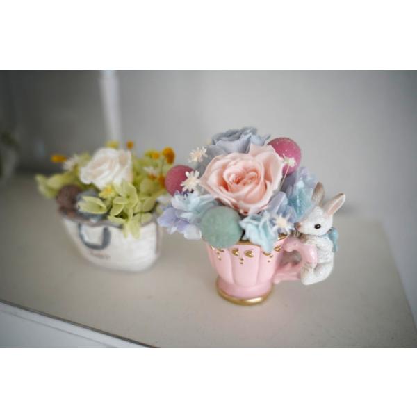 キーワード：小さな手のひらサイズのティーカップ型のベースとプリザーブドフラワーアレンジ。プレゼントにもお勧め！小さめのアレンジです。・サイズ(cm):w10xd8xh10cm・材料：プリザーブドフラワー（ロース、アジサイ小花）・カラー： ピ...