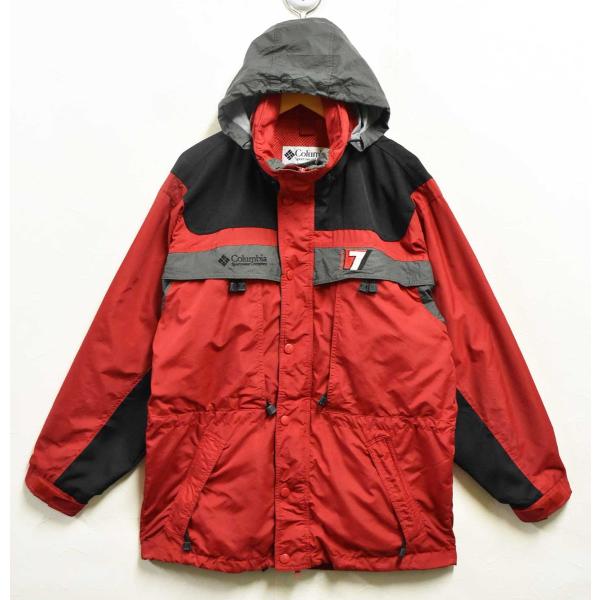 「Columbia」ビンテージ90'sのナイロンジャケットです！色ごとに違う生地感や長めの丈などがとても良い雰囲気ですのでコーディネートのポイントとして大活躍してくれます！本当にお勧めです！フードは襟部分に折りたたんで収納可能です。内側はメ...