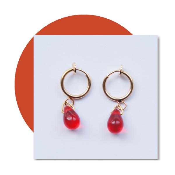 バネ部分をスライドさせて耳たぶを挟むピアス穴をあけていなくても、着用するとピアスのようなノンホールタイプのフープイヤリングゴールド色のフープイヤリングに華やかな赤色のドロップ型ビーズを装飾しましたビビットな色合いの赤色のチェコビーズは、大人...