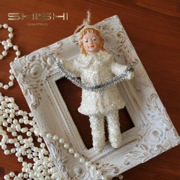 柔らかな表情で微笑むクリスマスの精霊（エスプリ）のオーナメントです。暖かな冬の装いでシルバーのガーランドを手にしています。まるで一緒にクリスマスデコレーションを手伝ってくれているかのようですね。陶器のような質感で、長い歳月を経てきたようなア...