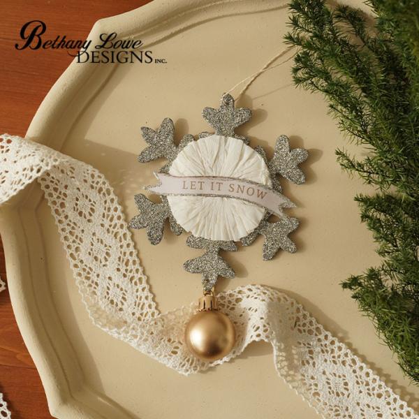 おしゃれなスノーフレークのオーナメントです。キラキラとグリッターが散りばめられた六角形の雪の結晶にゴールドのオーナメントボールがひとつ吊るされています。中央にはペーパークラフトの可愛らしい白い花と「LET IT SNOW（雪を降らせよう）」...