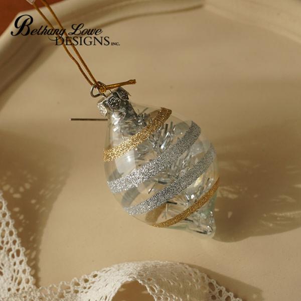 透明なガラスボールにシルバーとゴールドのストライプが描かれた、おしゃれなオーナメントです。クリアボールとキラキラ輝くグリッターを組み合わせたオーナメントは、シンプルならがも存在感を感じられるデザインに仕上がっています。ボールの中のシルバーモ...