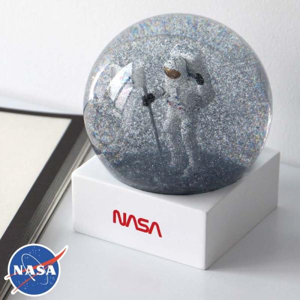 月面に立つ宇宙飛行士をモチーフにしたスノードーム。手に掲げた「ARTEMIS(アルテミス)」の旗が、次世代の月探査ミッションを象徴しています。ドームを揺らすと銀色の粒子が舞い、月面の砂埃のような幻想的な風景が広がります。注目を集めるアルテミ...