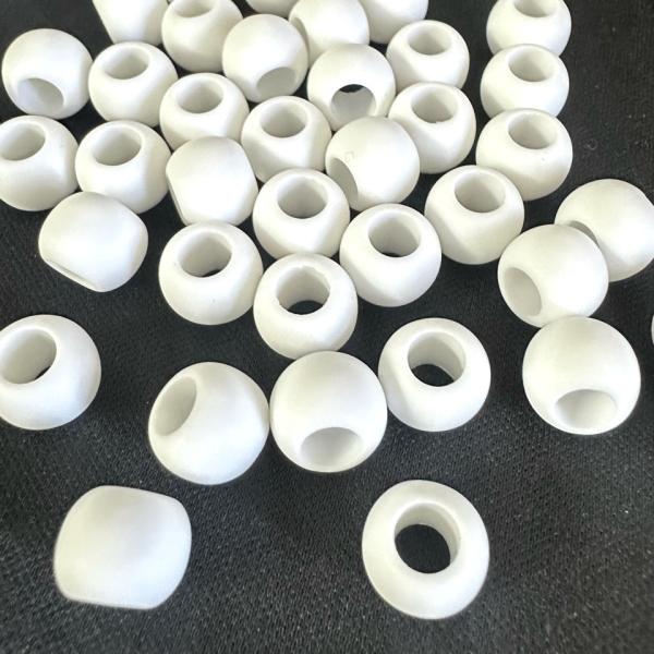 手芸のワンポイント、アクセサリー作りに。アジャスター用ビーズやループエンドに使えます。パラコードなどの太めの紐にも使用出来る大きめな穴の仕様です。60個セットでの販売です。サイズ　約10x8mm穴：約 4.5mmカラー 艶消しホワイト素材 ...