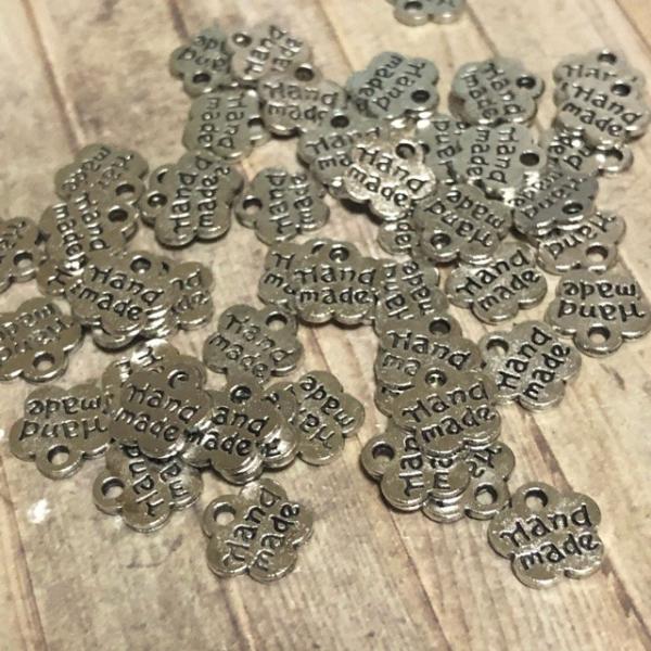 Hand made と刻印された小さなチャームです。プレゼントのラッピングや手作り品のタグ代わりにおすすめです。30個セットでの販売です。サイズ 約 8×8mmカラー シルバー素材 合金 Alloy同タイプのシルバーカラーはこちらで販売中で...