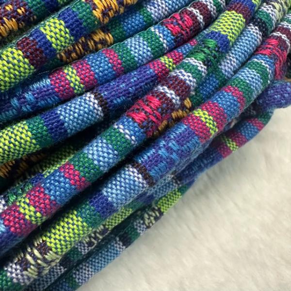 エスニック柄のコード(紐)です。1メートル での販売です。2点以上のご注文の場合は極力カット無しの全て繋がっ状態で納品致します。ご注文数が20m等多い場合は10mずつが2点など分かれてしまう場合もございます。商品の特性上、布地部分に繋ぎ目の...