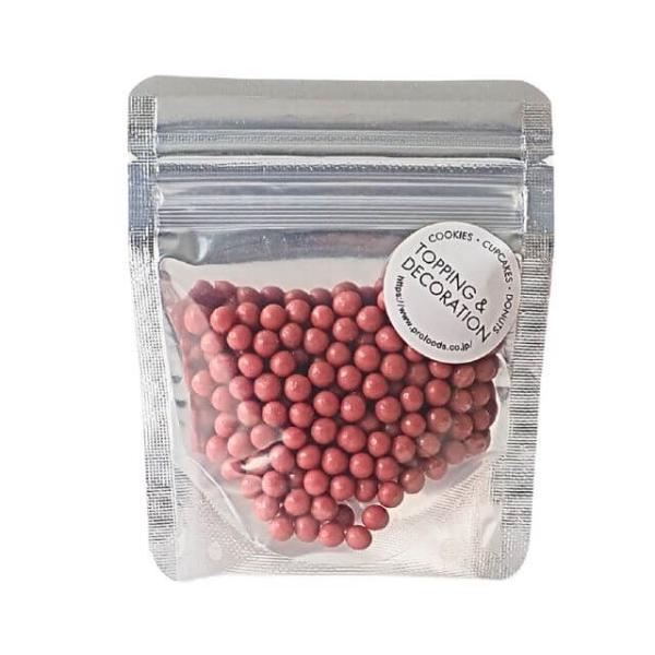 サクサクとした食感のシリアルをチョコレートでコーティングした、光沢のあるパール型ルビーチョコレート。お菓子やパン、アイスクリームなどのトッピングにお使いください。