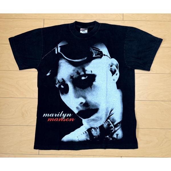 素材:綿100％[Lサイズ](約)着丈71cm/肩幅49cm/身幅53cm/袖丈19cmカラー:ブラック系生地、プリント共にビンテージ加工された古着感満点のレアデザインのマリリンマンソンのロックTシャツです。 インナー使いや一枚で主役にもど...