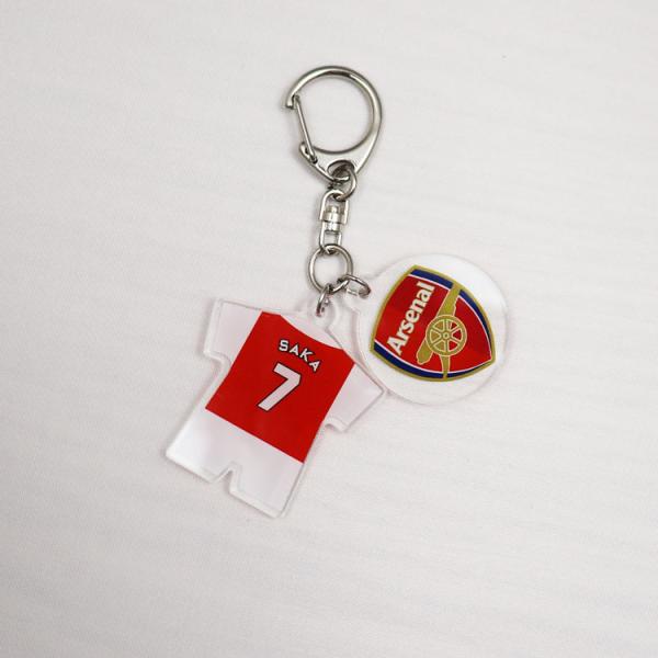 クラブ公式ライセンス商品英プレミアリーグの名門　アーセナルFCクラブエンブレムとユニフォーム型のアクリル2連チャームキーホルダー。イングランド代表　ブカヨ・サカ選手モデル。サイズ：40ｘ40mm（ユニフォーム部）/30ｘ30mm（エンブレム...