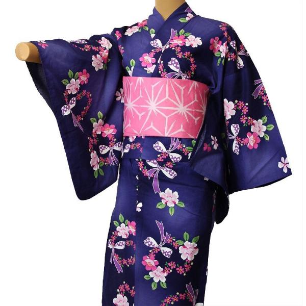紺色地に小花でハート形を描きました。サクラとリボンがアクセントです。伝統的な紺色のベーシックな浴衣です。ゆかた、帯、げた、着付け用品（ステテコ、だて締め、腰ひも）一式セットでお届けします。帯は代替品に変更になる場合がございます。Sサイズ適応...