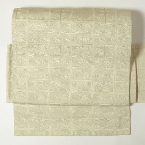 白地の格子の中に市松状に十字型を織り出しました。シンプルな文様の名古屋帯です。フォーマルな場面にもお使い頂ける名古屋帯です。