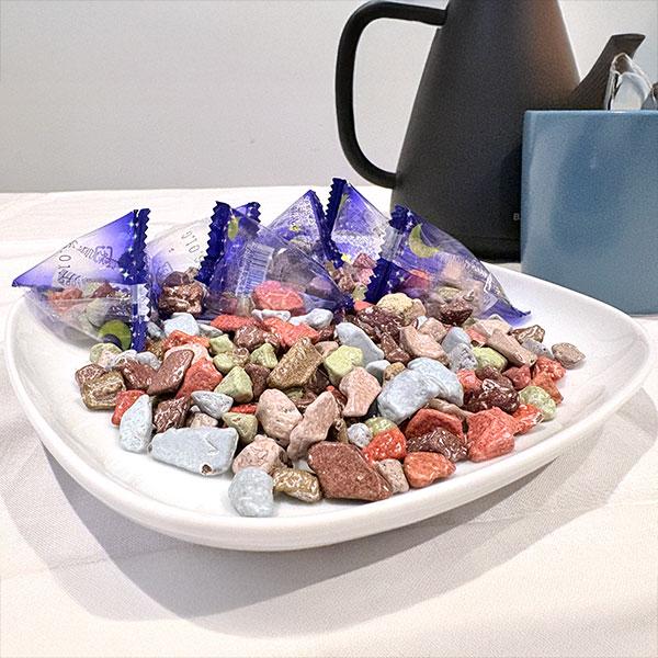 小石の形をしたカラフルなチョコレートをテトラ型のかわいい個包装にしました。チョコレートに糖衣掛けのコーティングを施しているので溶けにくく、食感も良いです。個包装にしているので、保存や小分けするのにも便利です。お茶請け菓子に個包装のまま出して...