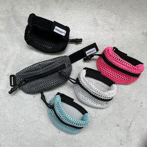 規則的にメッシュのパターンが変化している生地を使用したシリーズ。腕に巻いたりバッグのハンドルに巻いたりして使える小型のファニーパック。イヤフォンを入れたり車のキーやカード、お金など必要最小限の必需品を収納。ランニングなどスポーツ時にも最適。...