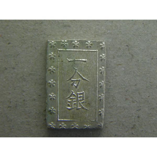 品位　銀８７３／その他１２７　量目８．６３ｇ　天保一分銀と比べますと、切り方が荒く、それが安政一分銀の特徴にもなっています。また、「是」字の第８画と９画が交叉しておらず、人になっています。側面の仕上げは、概して荒いやすり目が入っています。（...