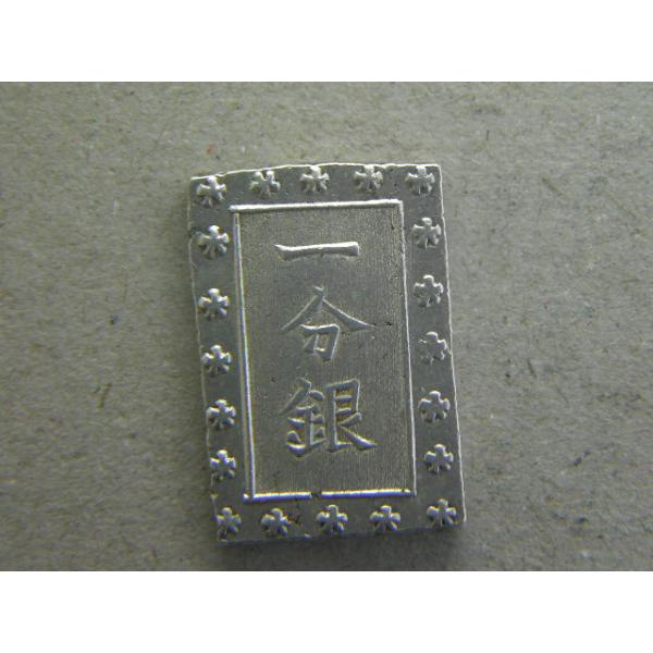 品位　銀８７３／その他１２７　量目８．６３ｇ　天保一分銀と比べますと、切り方が荒く、それが安政一分銀の特徴にもなっています。また、「是」字の第８画と９画が交叉しておらず、人になっています。側面の仕上げは、概して荒いやすり目が入っています。（...