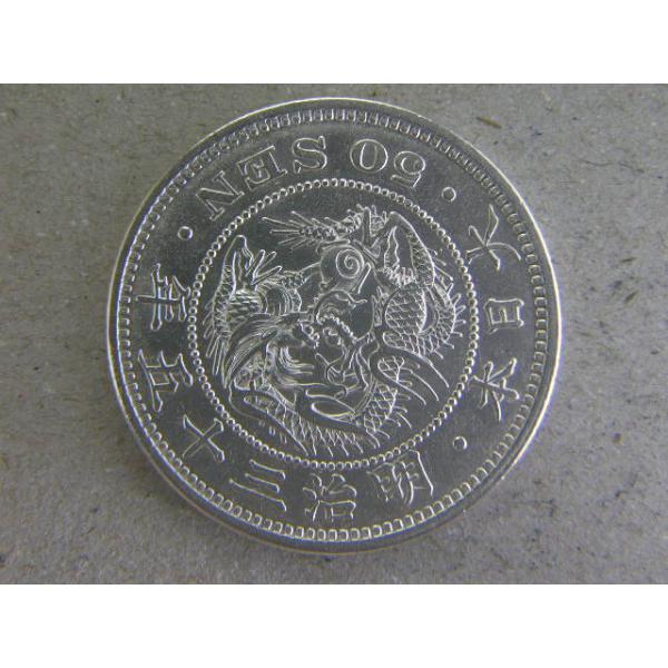 発行枚数102.3万枚 直径30.9ミリ 品位銀80.0％ 量目13.48ｇ  明治の堂々たる竜銀貨です。現代のコインとは違い、手の平に乗せるとずしりと持ち重りがします。発行枚数の少ない特年号です。