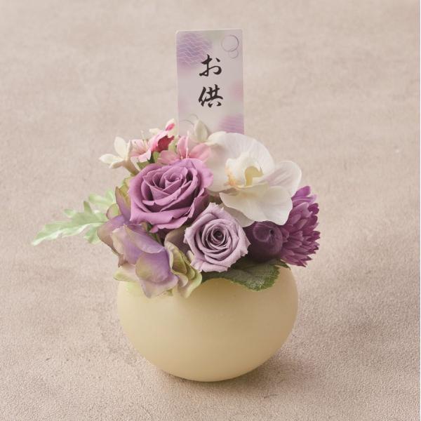 お悔やみの花　アレンジメント光葵（こうき）。丸みを帯びたコンパクトなサイズ感は小さなスペースの家庭祭壇にも飾っていただきやすく、また仰々しくなりすぎないご進物をお探しの方にも向いています。優しい灯りが灯るワックスベースを使用したアレンジです...