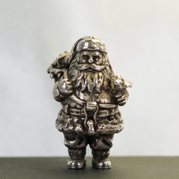 下半身と上半身が開きピル入れとなります。たくさんのプレゼントの袋を背負ったサンタさんです。留め金がついています。スペイン製置物　サンタクロースサイズ：29mm×36mm×49mm　約65g　材質：ピューター100％