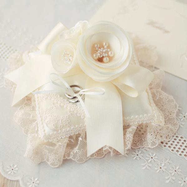 カメリアは日本古来から愛されている椿の花のこと。某ブランドのアイコンも白のカメリアですね。花言葉は「理想の愛」「完全なる美しさ」「永遠の愛」「至上の愛らしさ」など、愛や美の言葉が並びます。幅広のレースをあしらったリングピローの上に、パールが...