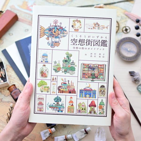 「絵本はないの？」 「空想の街の詳しい物語が知りたいな」 「もっと大きなサイズで街の絵を見たい」そんなお声にお答えして作られた空想の街の図鑑です！B5サイズの書籍です。開くとB4サイズでほぼ原画サイズの空想の街が一面に。次のページにはその街...