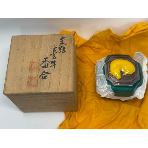 交趾臺牛香合です 鮮やかな緑の六角台座に 味わい深い紫の地 そして鮮烈な黄色の牛が浮き上がる 美しい色彩のコントラストが特徴です 丸くなって眠る牛の姿には愛嬌があり 交趾ならではの艶やかな質感が茶席に華を添えます 未使用の経年在庫品で状態は...