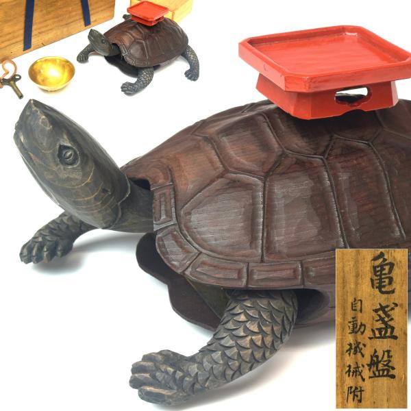 明治時代に造られた『木彫り からくり盃運び亀』です。細部まで丁寧に造られており時代を経た味わい深い作品です。ゼンマイを巻き、上部の台に盃を乗せるとノソノソとリアルな動きで前進します。経年に伴う擦り傷や汚れ、後ろ左足のゼンマイが外れています(...