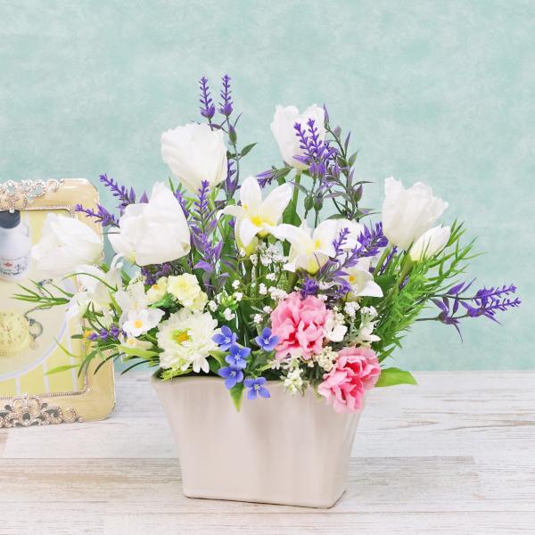 清楚なホワイトのチューリップにピンクのカーネーションがアクセントになったアレンジです帰省のお土産に、お盆やお彼岸のご挨拶にどうぞお荷物にならないように直接お届けも承ります。サイズ：約高さ26×幅27×奥行18cmシルクフラワーとは、シルクの...