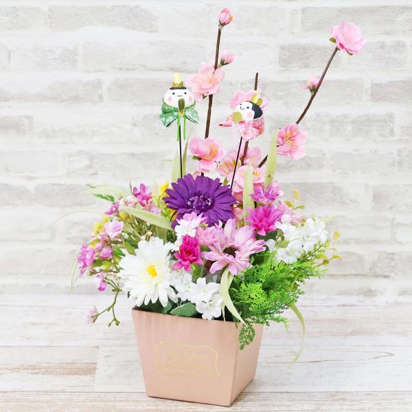 ピンクを基調とした色合いに紫が差し色となった小ぶりなアレンジです。サイズ：約高さ30cm×幅25cm×奥行18cm＊商品の仕様は変更になる場合がございます＊受注制作のため数日お時間をいただく場合がございます