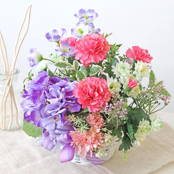 母の日に贈る、大輪のアジサイをメインに定番のカーネーションを添えたアレンジメントです。ホワイトのバスケットとたっぷりのグリーンで爽やかな色合いに仕上げました。アレンジメントサイズ：約高さ26cm×幅25cm×奥行22cmシルクフラワー(造花...