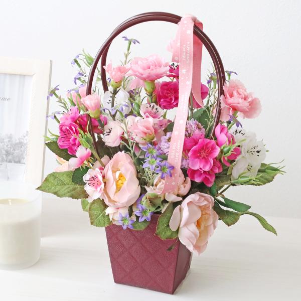 母の日に贈る、ソフトピンクのローズとカーネーションのアレンジメントです。持ち手付きバッグの器は、軽くて割れないので倒れても安心です。ワインカラーがおしゃれな格子柄のバッグに、色とりどりのバラをたくさんに咲かせました。アレンジメントサイズ：約...