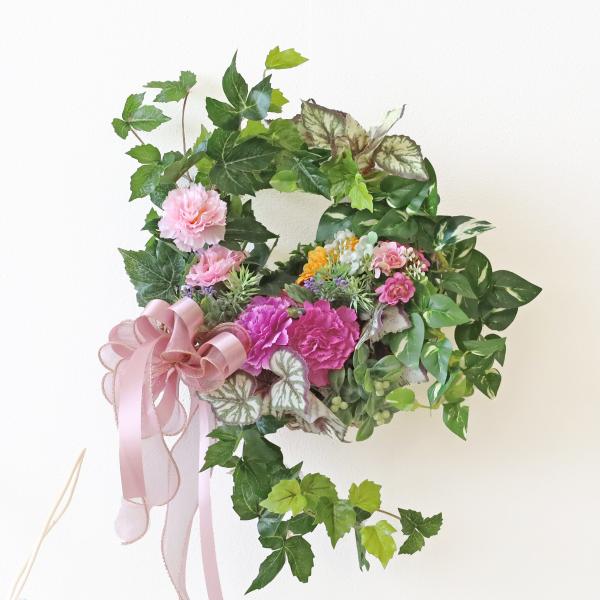 母の日に贈る、アイビーと3色のカーネーションのリースアレンジメントです。たっぷりのグリーンが爽やかな印象のリースは、どんなお部屋にも馴染み、インテリアとして長くお楽しみいただけます。定番カーネーションに、ふんわりと揺れるピンクオーガンジーの...
