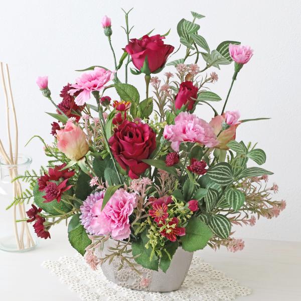 母の日に贈る、ローズとカーネーションのアレンジメントです。ツヤのある鏡のような花器は、光を取り込むことで美しく輝き、高級感があります。和風な小花を添え、どんなお部屋にも合う和洋ミックスのデザインに仕上げました。アレンジメントサイズ：約高さ3...