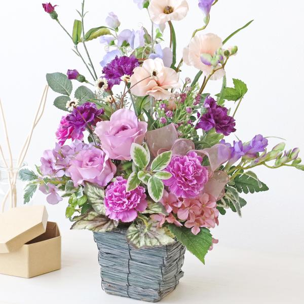 母の日に贈る、バイオレットのカーネーションとラナンキュラスのアレンジメントです。シックなバスケットの器は、軽くて割れないので倒れても安心です。パープルカラーのグラデーションが美しく、高さのある形が華やかでクールな印象のデザインです。アレンジ...