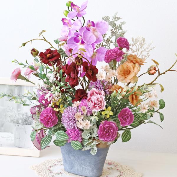 母の日に贈る、胡蝶蘭とバラ、カーネーションの豪華なアレンジメントです。シックな色合いのお花には、流れるような鏡のラインが入った器を合わせて、モダンなデザインに。繊細な葉や豪華な胡蝶蘭が大きく広がる、飾り映えのするアレンジです。アレンジメント...