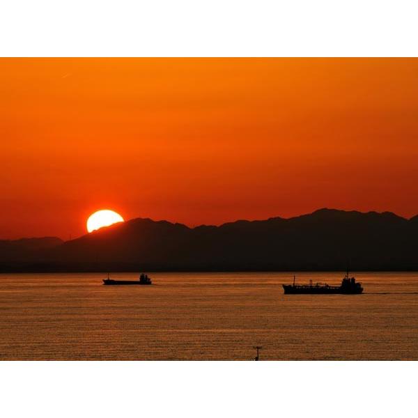 沈みかけている夕日、その前を行く船、夕方の伊勢湾を象徴している一枚です。真っ赤な夕空と、海面に映った茜色、とても綺麗です。額に入れても、パネルにしても、何処に飾っても映えます。写真サイズ・四ッ切りワイドサイズ。