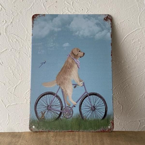 か、、かわいい！！（目はハート）海外のサイトで見かけ、迷わず取り寄せたブリキ看板です。ゴールデンレトリーバーが自転車に乗っています。ドット柄のバンダナをつけ真っ直ぐ前を向いて、自転車を漕いでいるつもりでしょうが足はペダルに届いていません。ア...