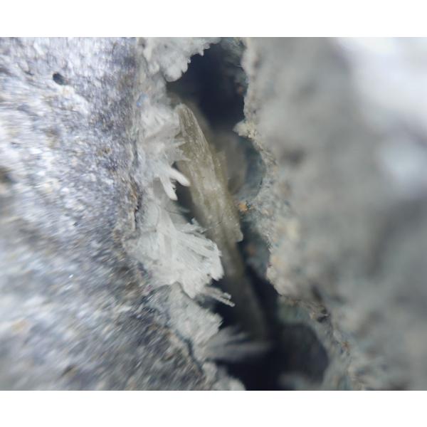 ネオジムランタン石(LANTHANITE-(Nd))産地　佐賀県東松浦郡肥前町満越第四紀のアルカリ玄武岩の空隙に板状の結晶として見られます。白熱灯〜太陽光では淡いピンク色ですが、蛍光灯のもとでは帯青白色に変化します。あられ石や玉滴石を伴って...