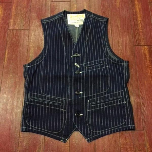 シュガーケーンの9オンス　ウォバッシュワークベスト前身頃にウォバッシュストライプ生地、後身頃に11オンスのデニム生地を使用したワークベスト。第1ボタンと第2ボタンの間のボタンホールは、懐中時計のチェーンを留めるためのディティール。ウエストは...